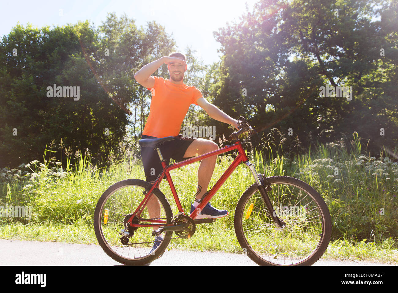 happy young man riding bicycle outdoors Stock Photo - Alamy