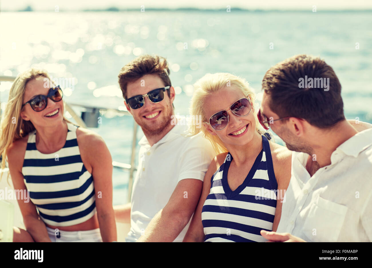 smiling friends sitting on yacht deck Stock Photo - Alamy