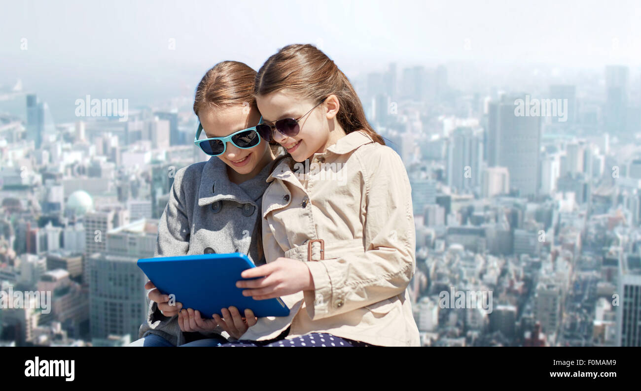 happy girls with tablet pc computer over city Stock Photo - Alamy