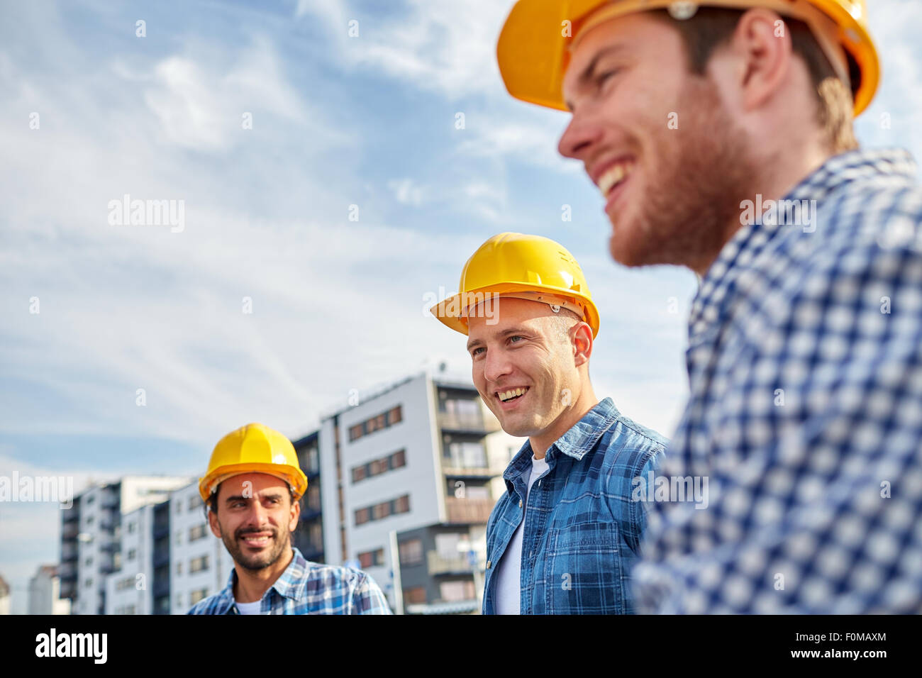 group of smiling builders in hardhats outdoors Stock Photo - Alamy