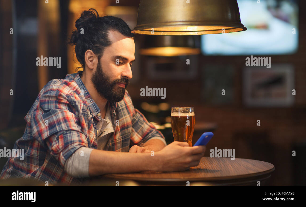 man with smartphone and beer texting at bar Stock Photo - Alamy