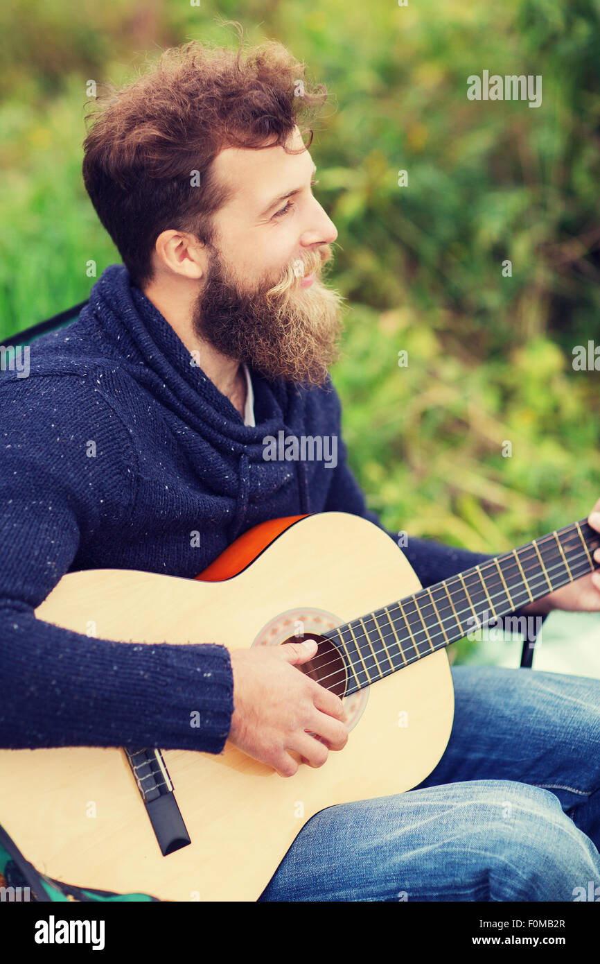 smiling man playing guitar in camping Stock Photo - Alamy