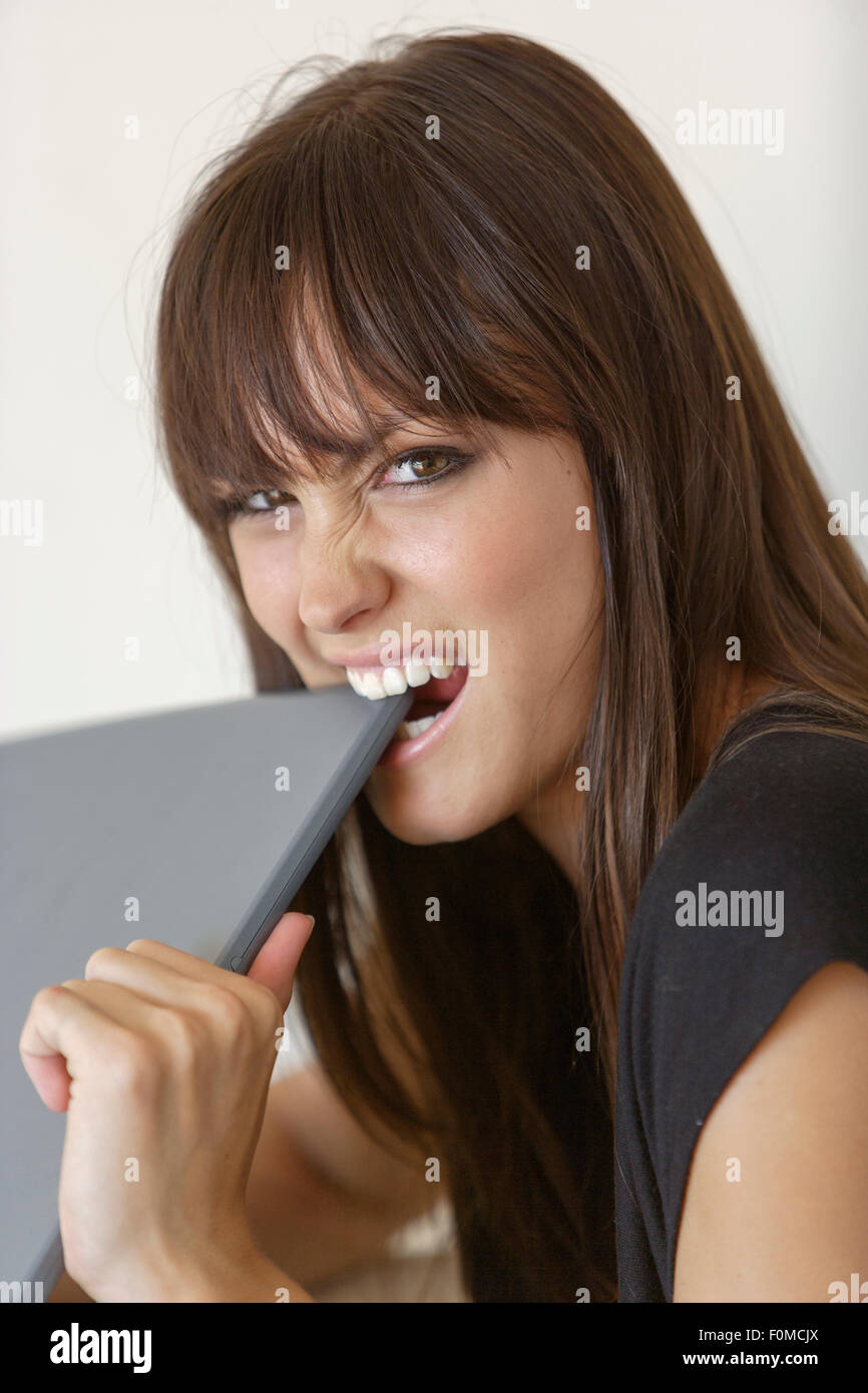 Young woman biting in Laptop computer Stock Photo - Alamy