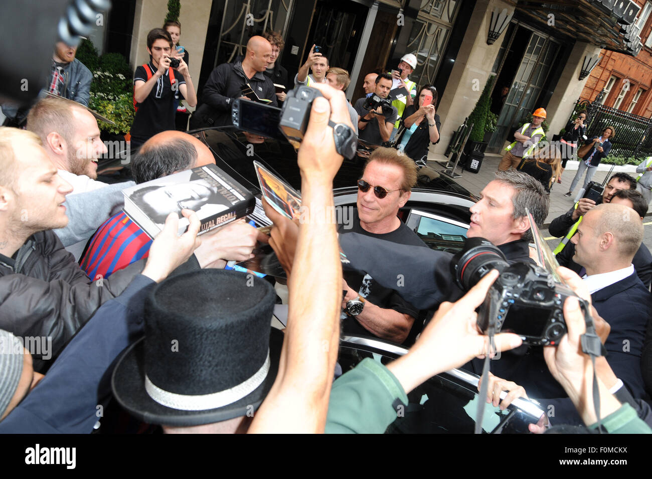 Arnold Schwarzenegger signs for fans as he leaves Claridges Featuring ...