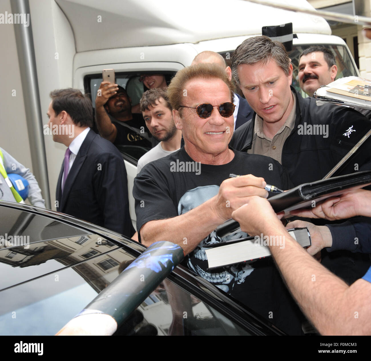 Arnold Schwarzenegger signs for fans as he leaves Claridges Featuring ...