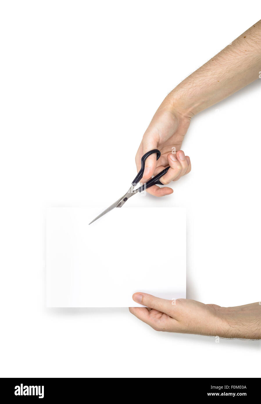 A woman is cutting a sheet of white paper using metallic scissors ...