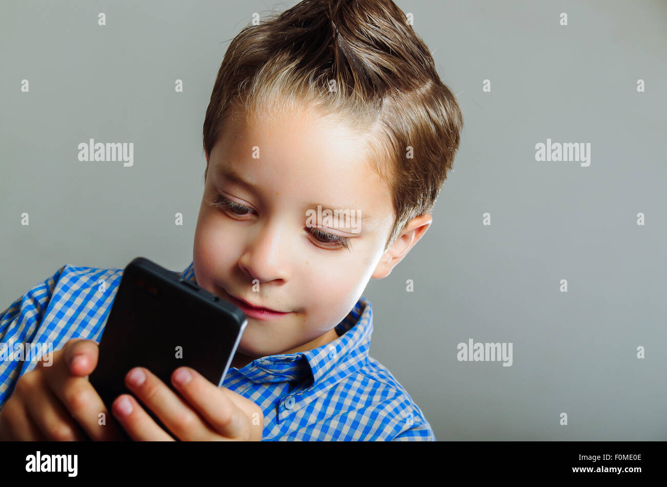 Cute boy using cell phone Stock Photo - Alamy