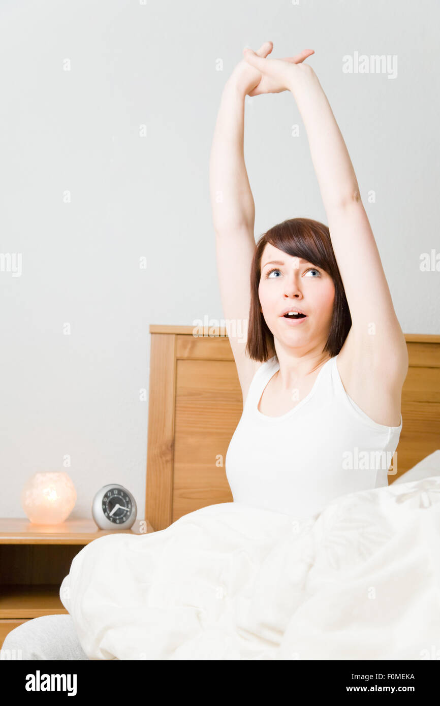 Young woman waking up in her bed Stock Photo - Alamy