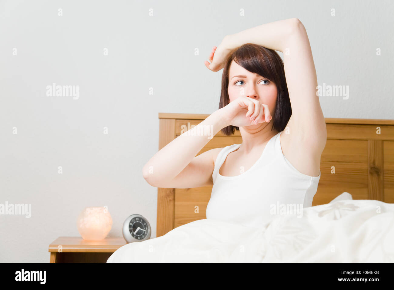 Young woman waking up in her bed Stock Photo - Alamy