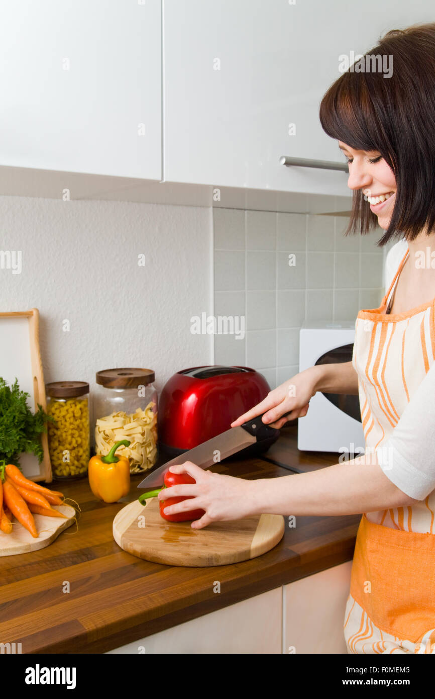 Young woman in her kitchen cutting ingredients Stock Photo - Alamy