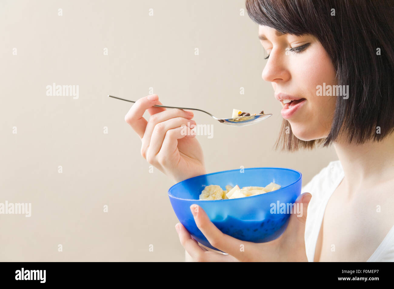 Young woman eating a bowl of muesli Stock Photo - Alamy