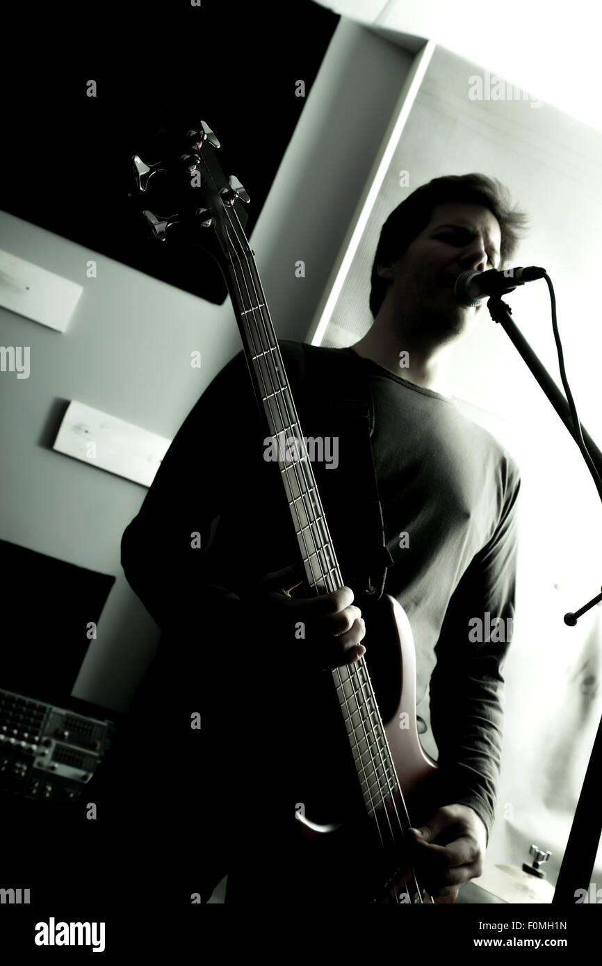 Black and white Portrait of a Rock singer playing bass in the rehearsal ...