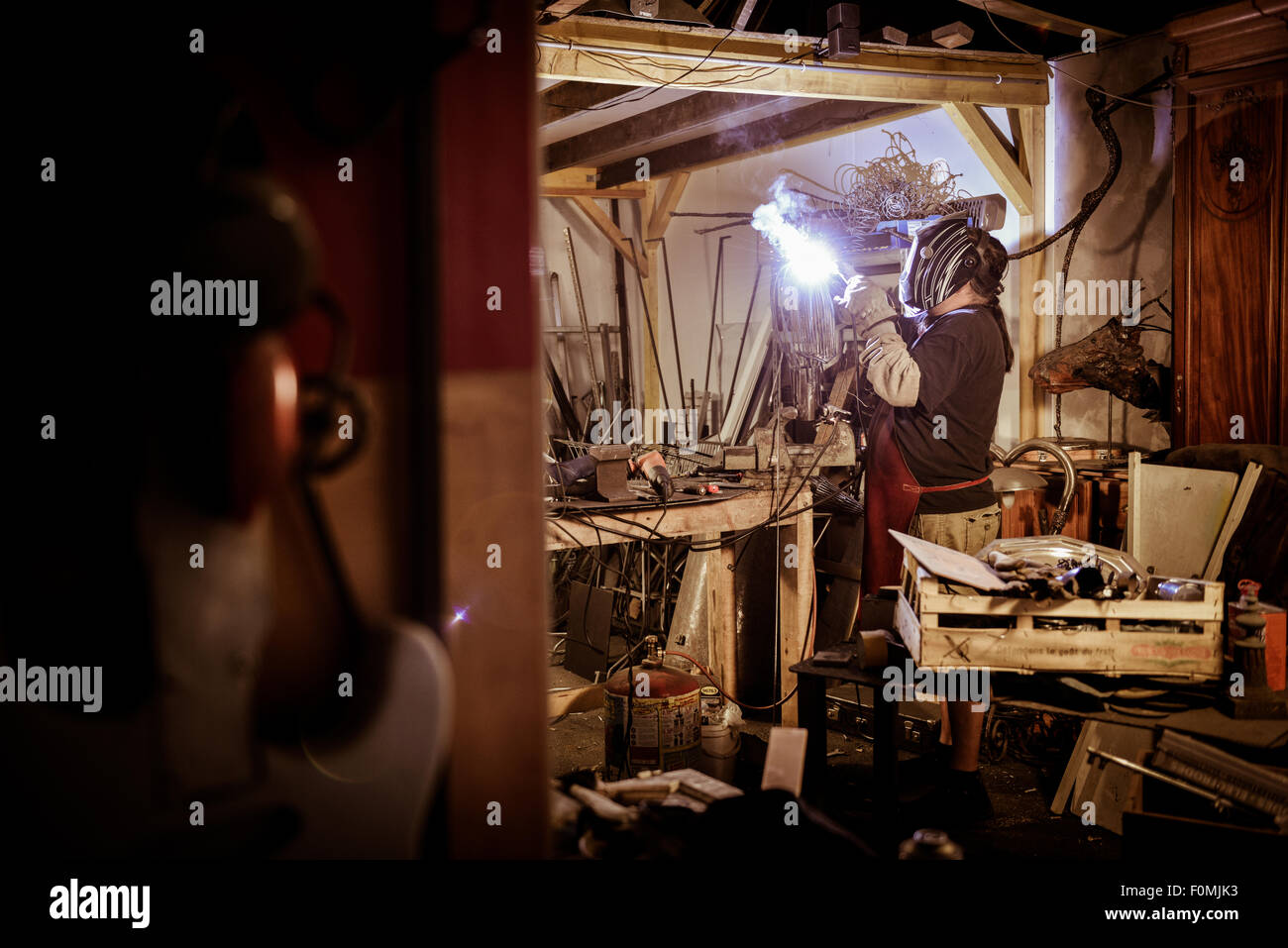 Welder wearing face mask and protective gloves in factory Stock Photo ...