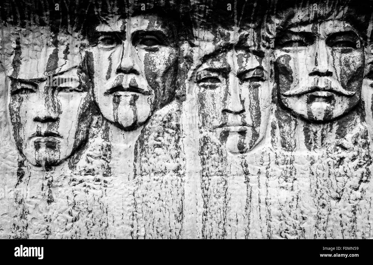 Stone carved faces on white marble rock with signs of aging Stock Photo ...
