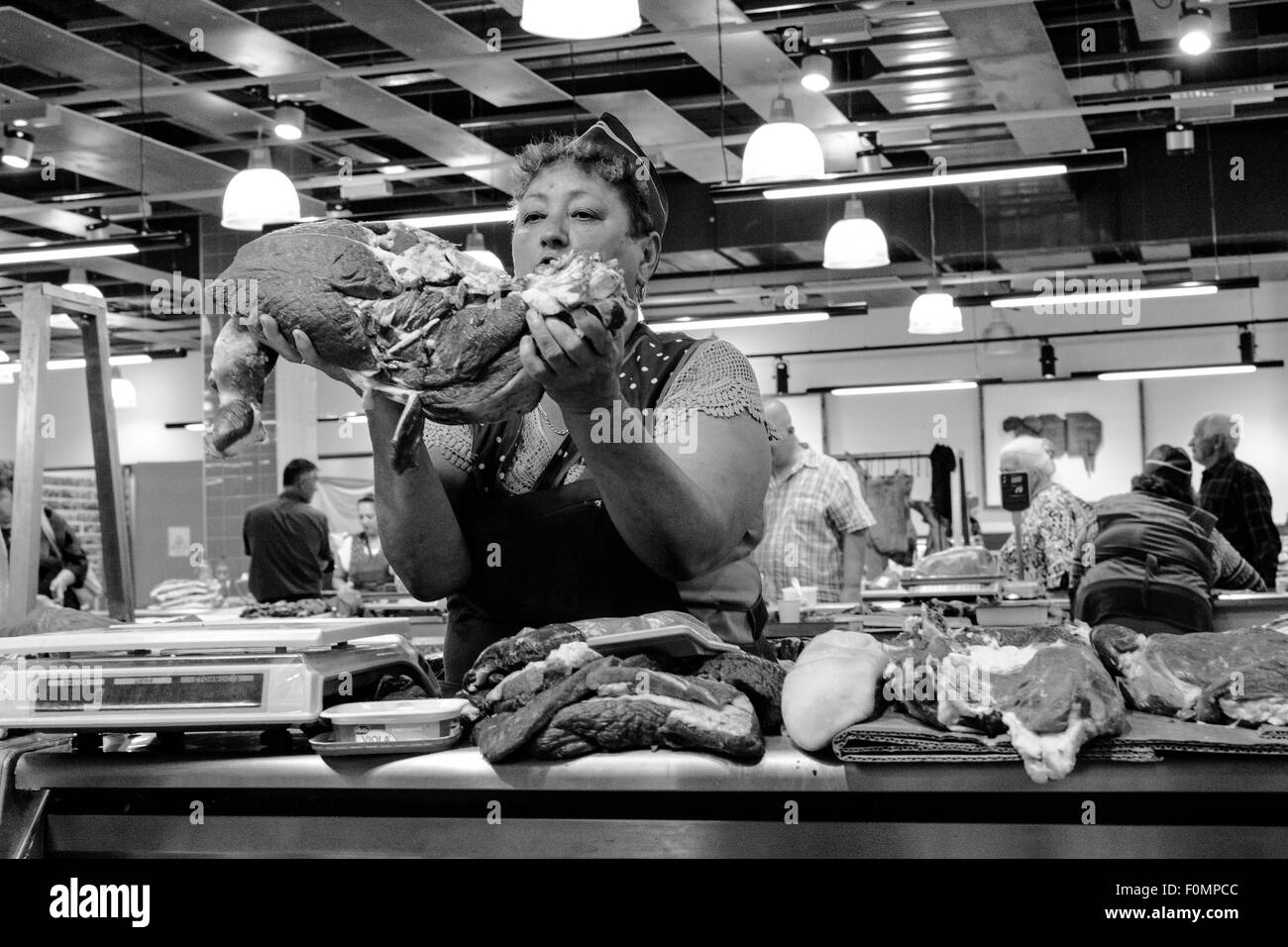 Meat seller shows a huge chunk of meat as an advertisement for shoppers ...