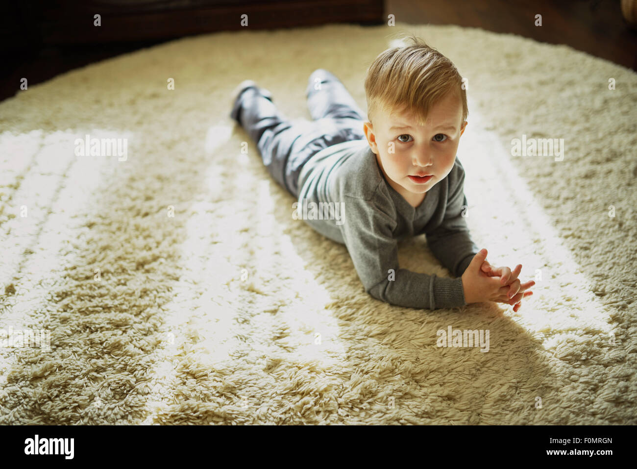 little boy lying on the carpet Stock Photo - Alamy