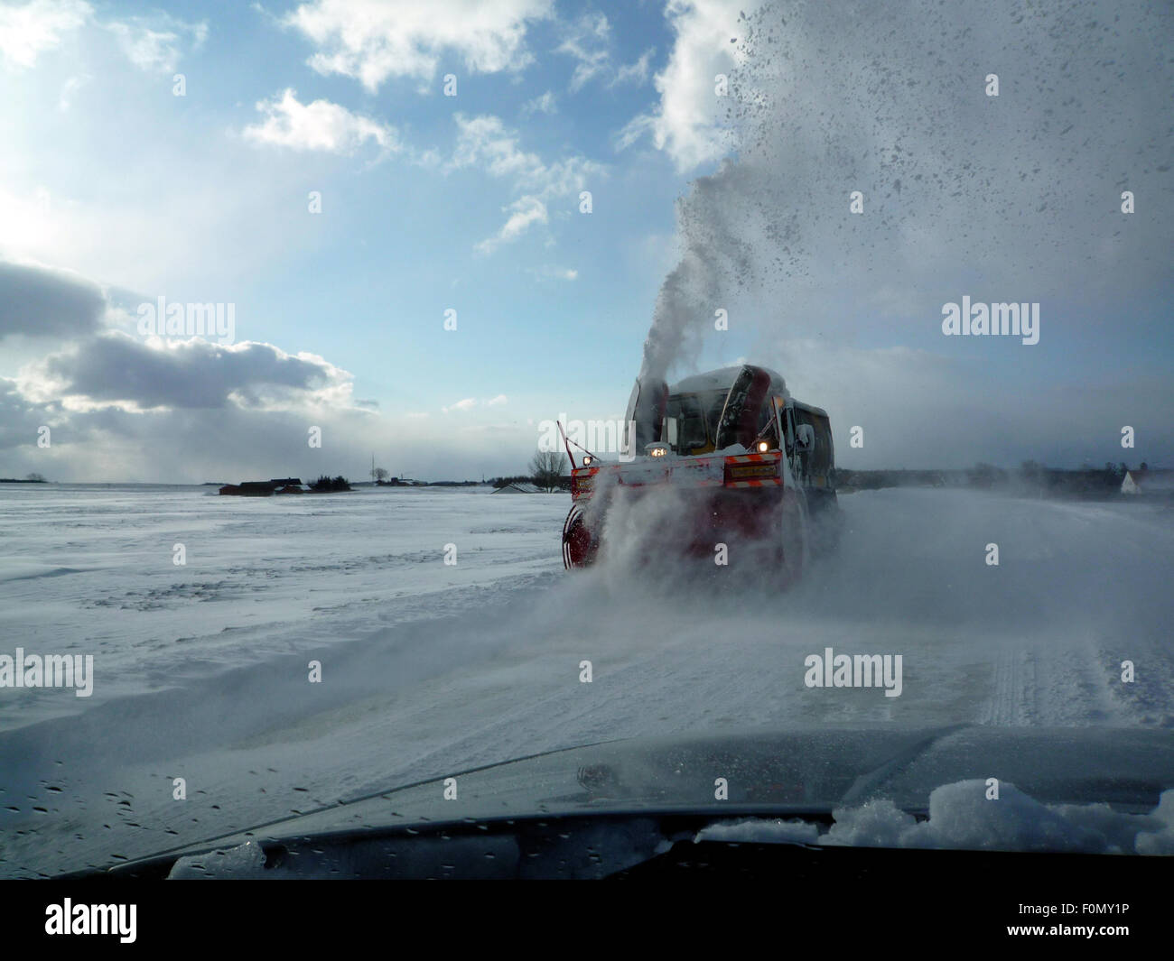 Snowblower clears the road. Clouds and snow Stock Photo - Alamy