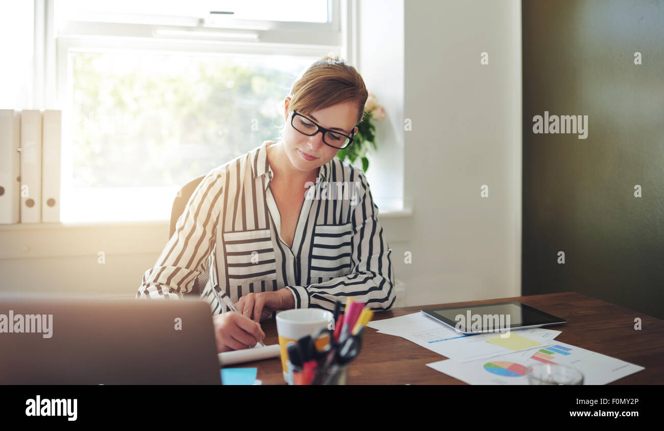 Pretty Young Businesswoman Writing Some Notes on her Desk Inside the ...