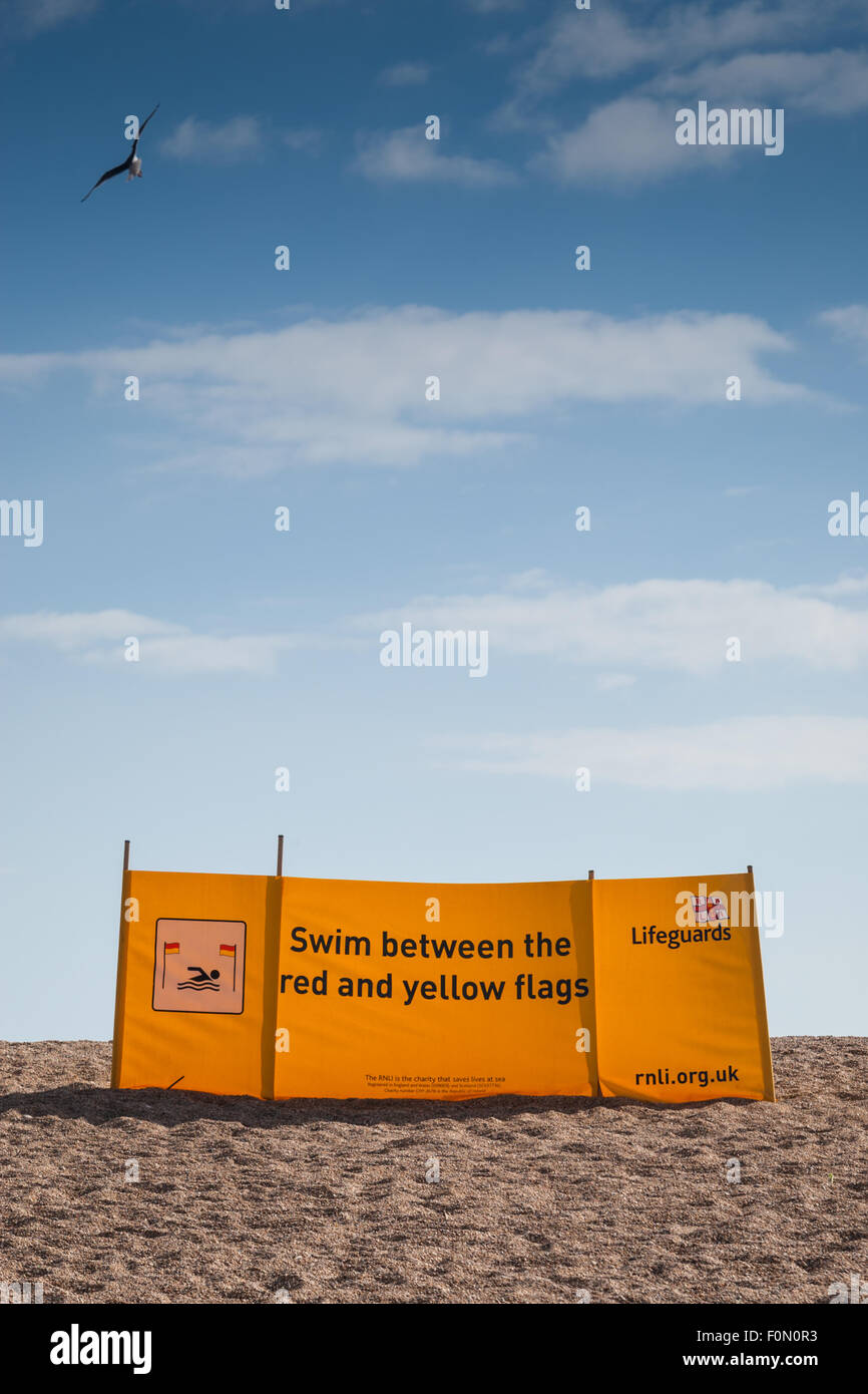 RNLI beach windbreak telling beach visitors to swim between the red and ...