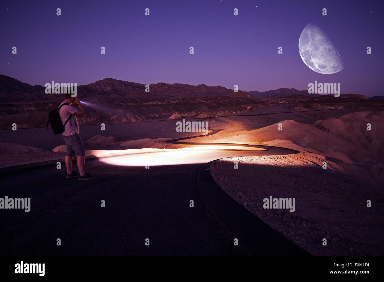 Hiker with Powerful Flashlight on Death Valley Trail During Starry ...