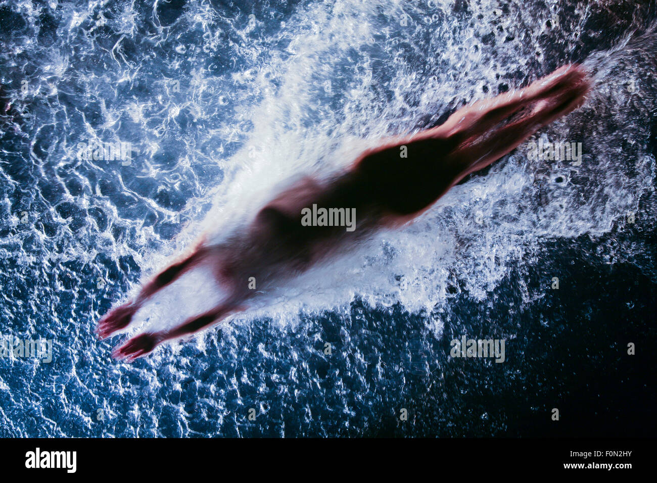 Underwater full length portrait of a woman plunging in a tropical ...