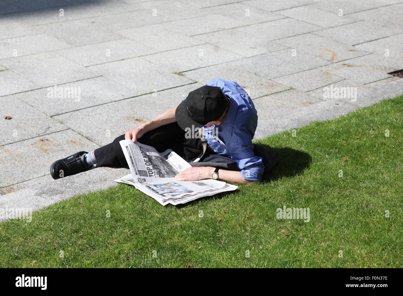 UK Weather: 18th August 2015. A Man Reading a newspaper in the Summer ...