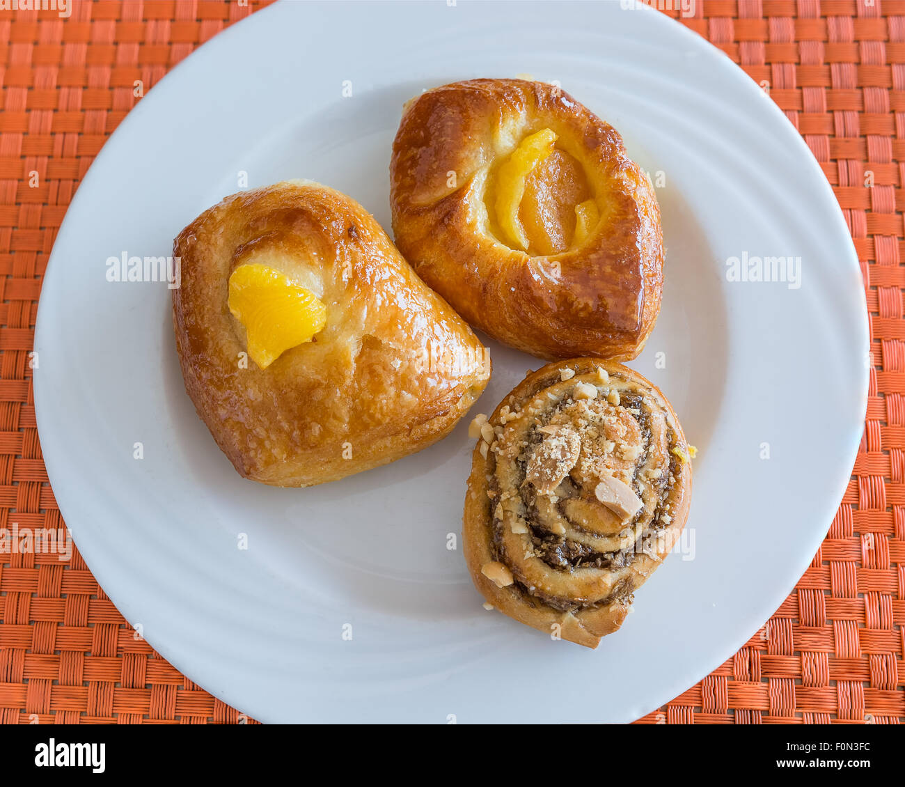 In the pictured three pastries served on a white plate Stock Photo - Alamy