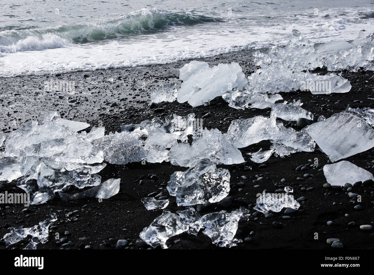 Glacial ice washed up on black sand beach at Jokulsarlon, southern ...
