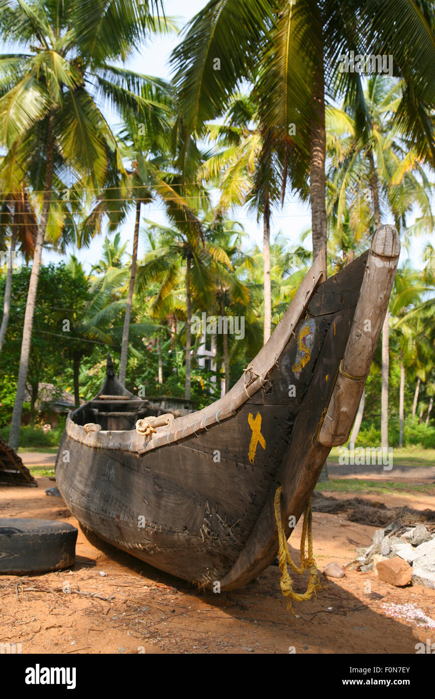 Traditional kerala fish boat laying on the beach near varkala with ...