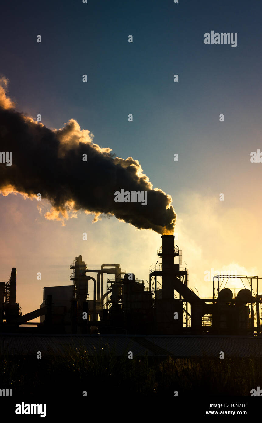 Smoking chimney at sunset on industrial buildings complex Stock Photo ...