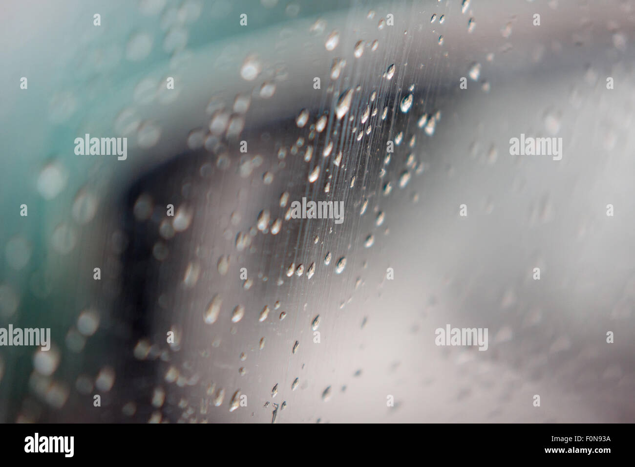 drops of a rain flow down on automobile glass casting grief Stock Photo ...