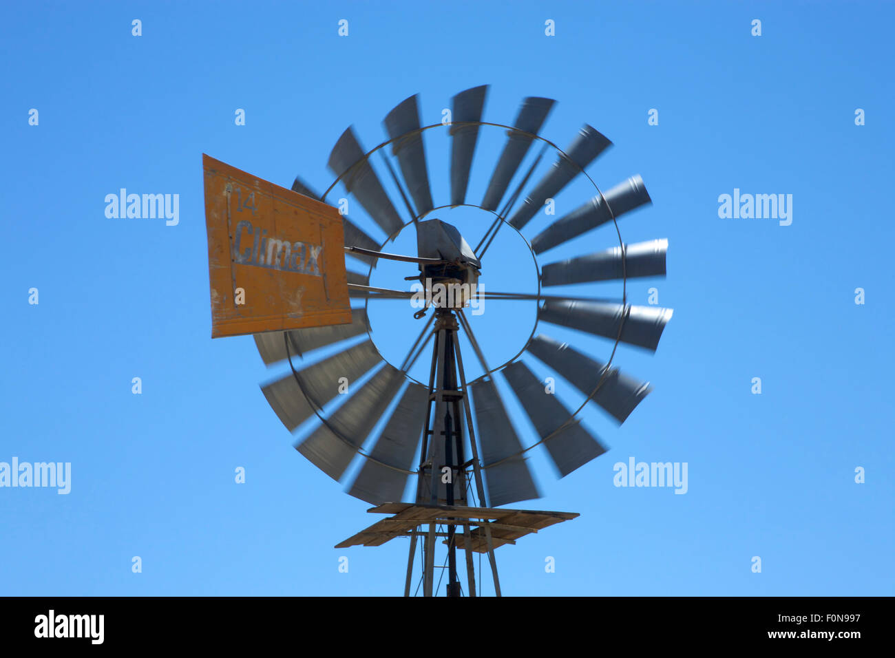 Detail of a bore water wind mill in action with a blue sky somewhere in ...