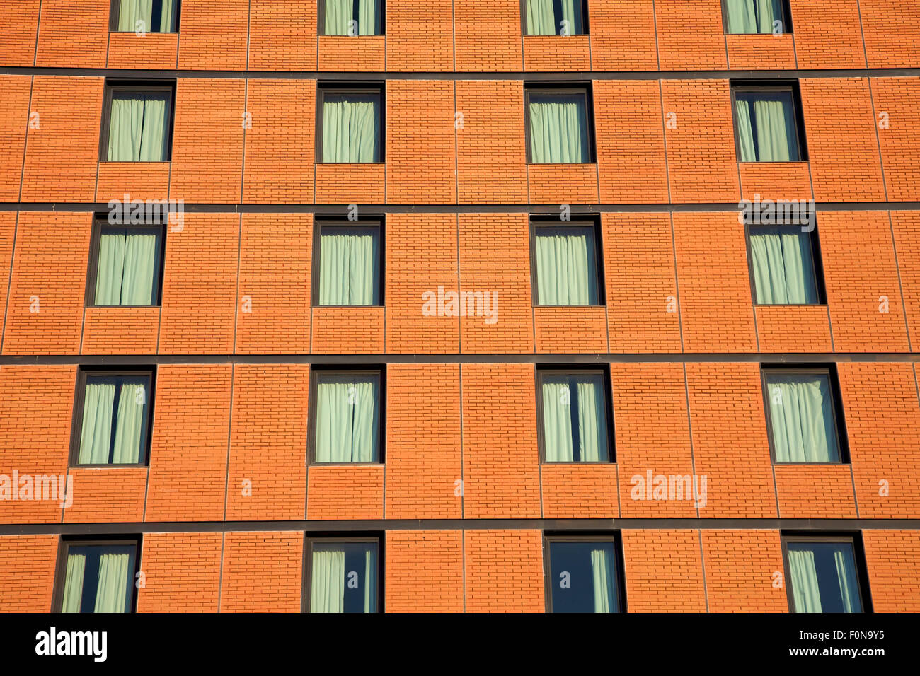 Facade of a brick office building with successive rows and floors of ...