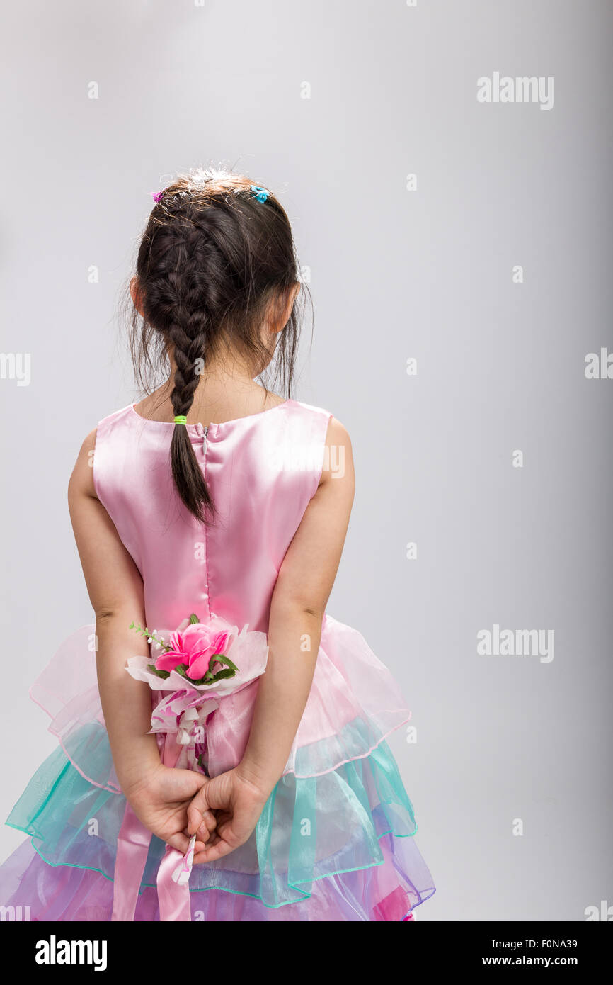 Rear view of cute Asian girl holding flower Stock Photo - Alamy