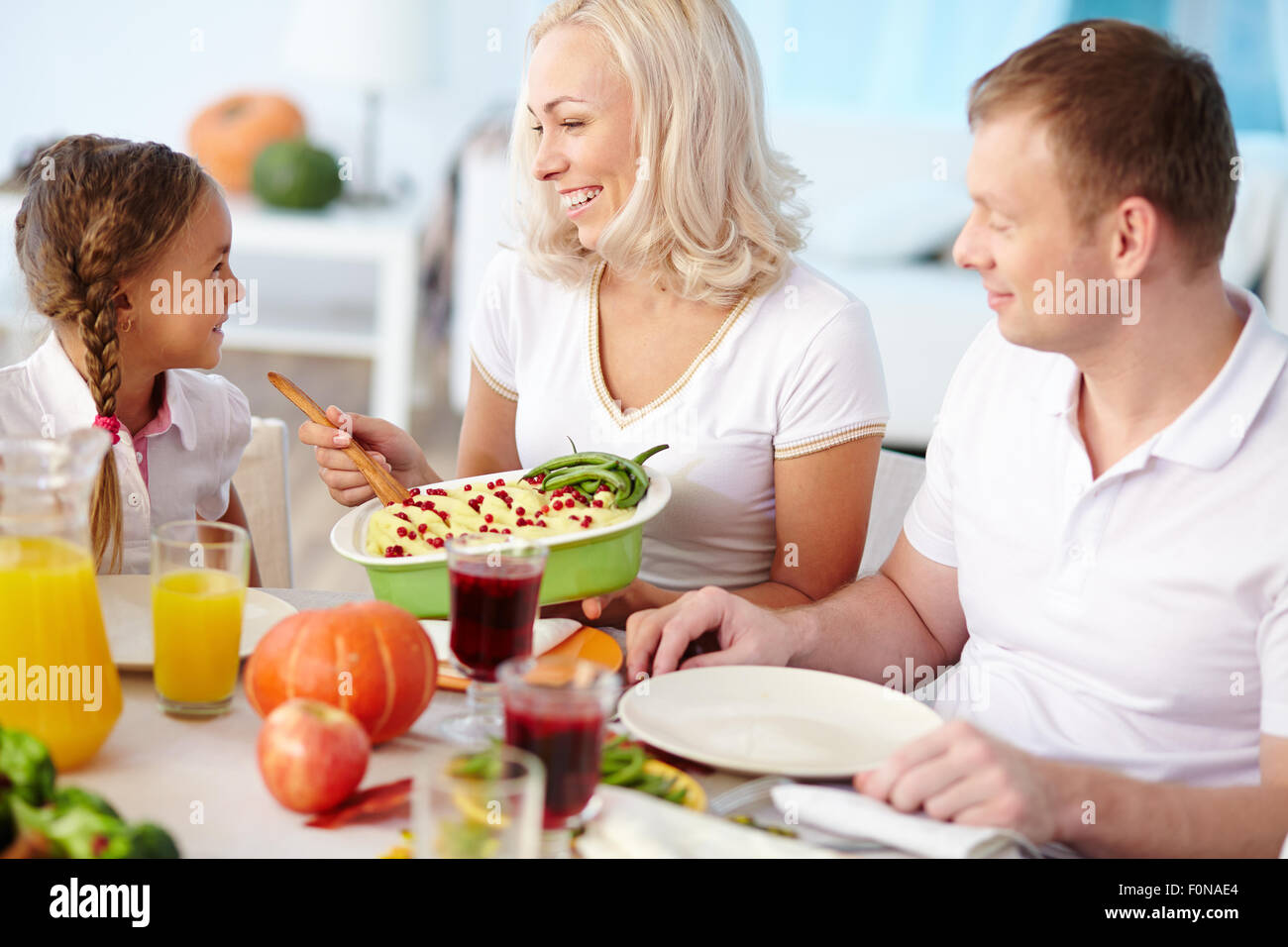 Happy family of three dining together Stock Photo - Alamy
