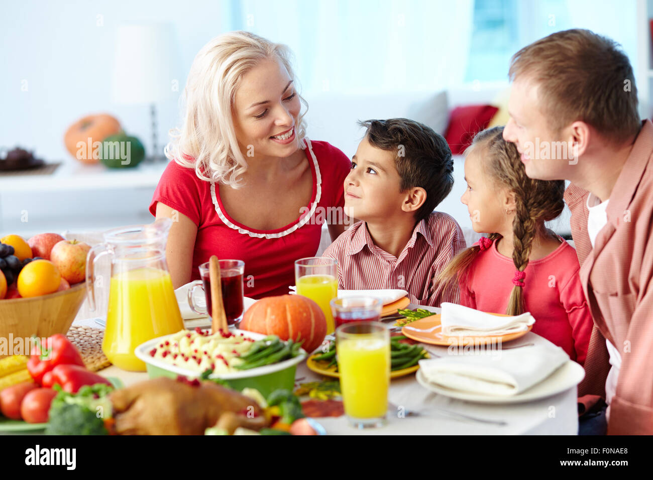 Family of four gathering at dinner table Stock Photo - Alamy