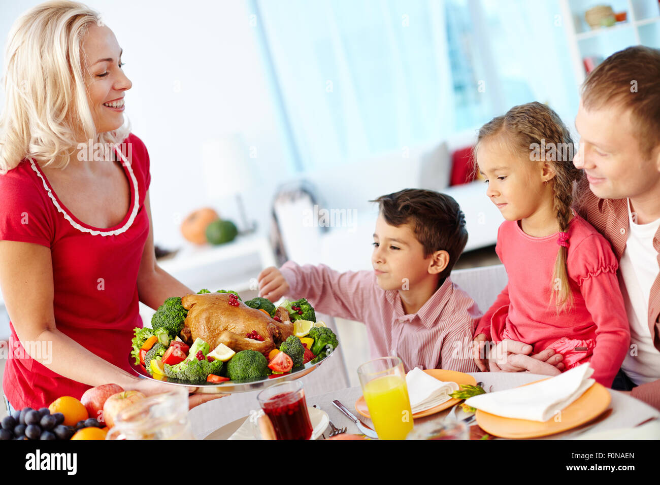 Mother serving chicken for dinner Stock Photo - Alamy