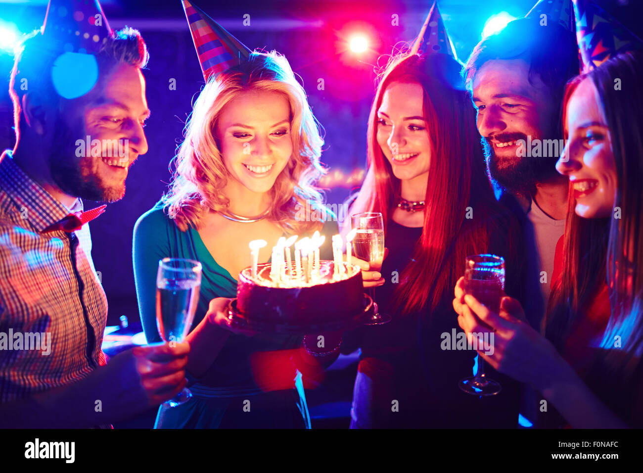 Young people around birthday cake Stock Photo - Alamy
