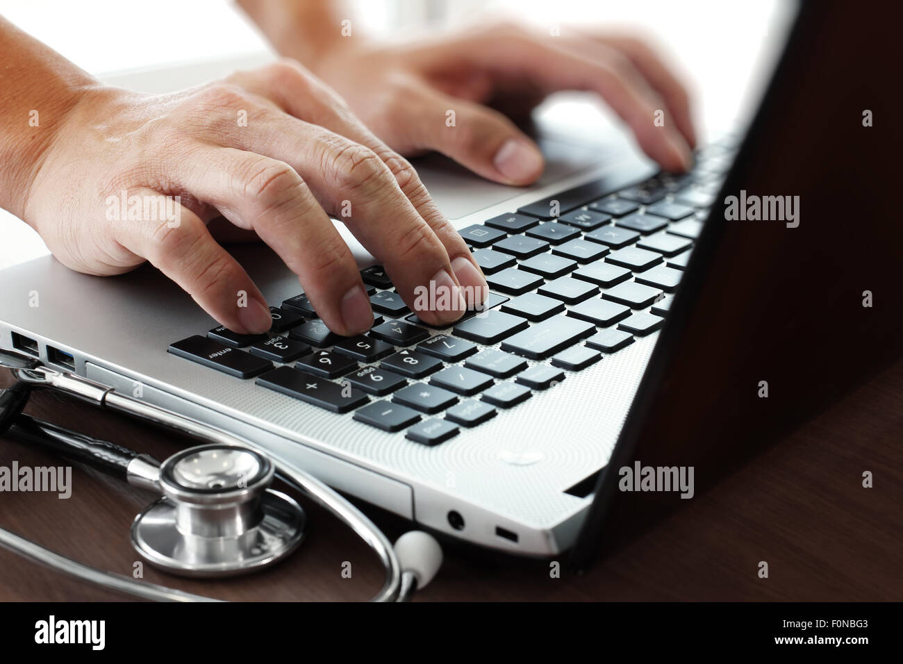 Doctor hand working with laptop computer in medical workspace office as ...