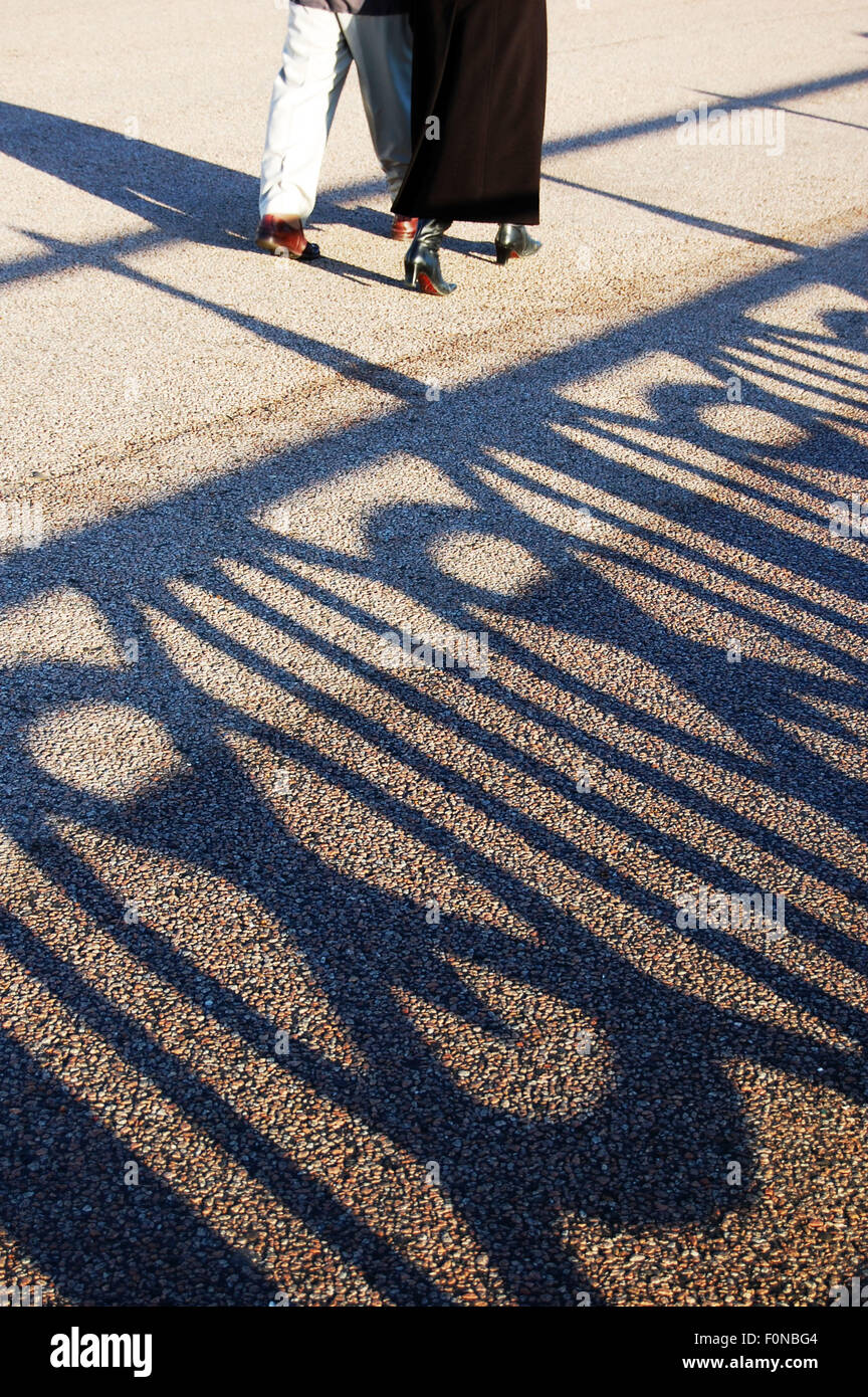 two people walking on Hove seafront with long shadows Stock Photo - Alamy