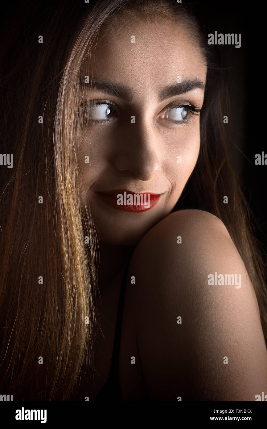 happy smiling woman looking over shoulder on black background Stock ...