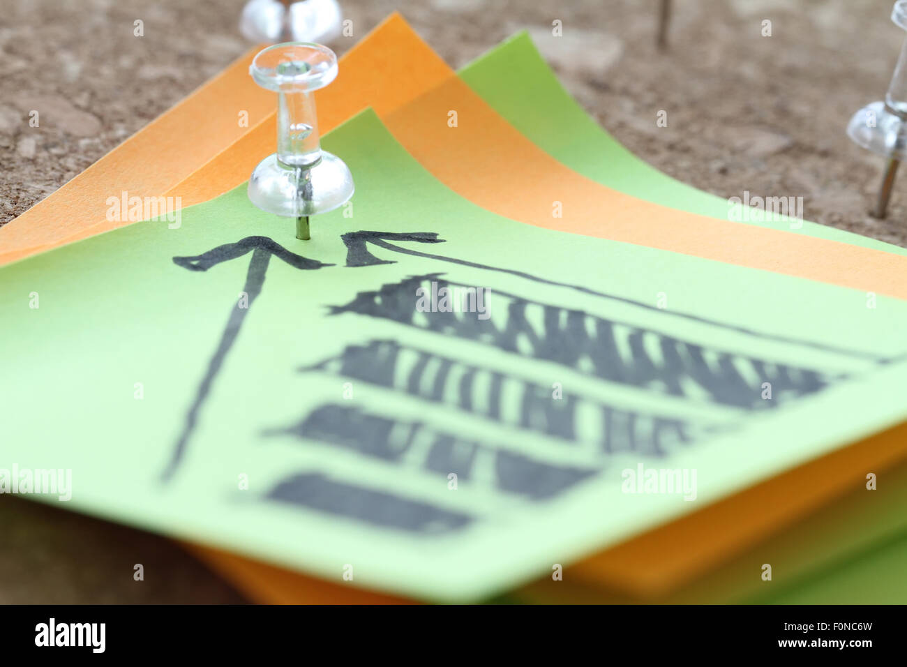 close up of pin and hand drawn business strategy graph chart on sticky ...
