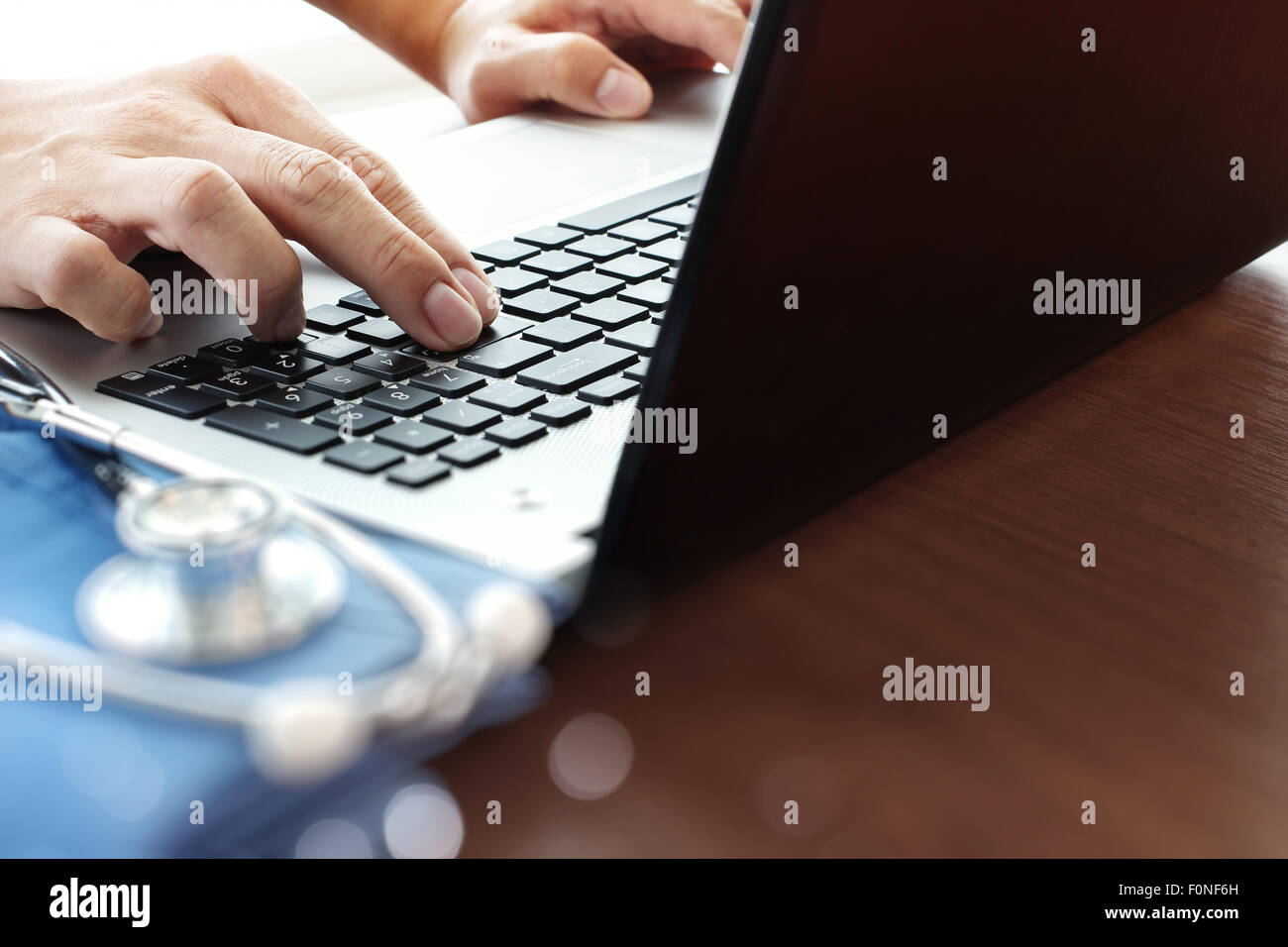 Doctor working with laptop computer in medical workspace office as ...