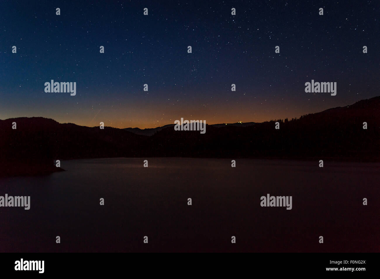 stars moving in night sky over mountain lake Stock Photo - Alamy