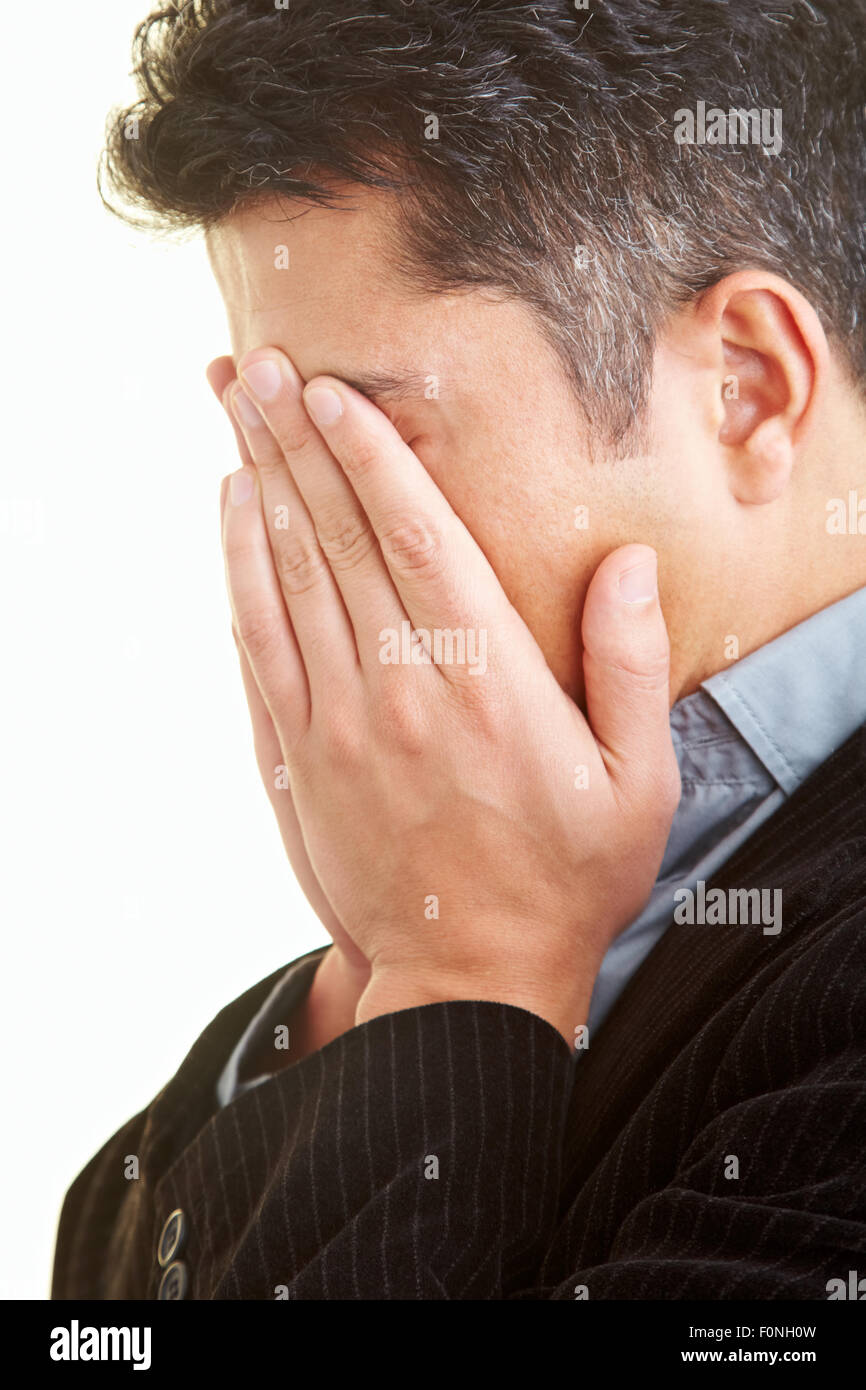 Businessman covering his face with both hands Stock Photo - Alamy