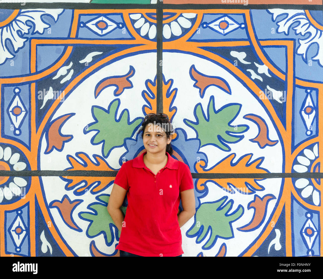 Cute Goan girl standing in front of colorful tiled modern azulejo wall ...