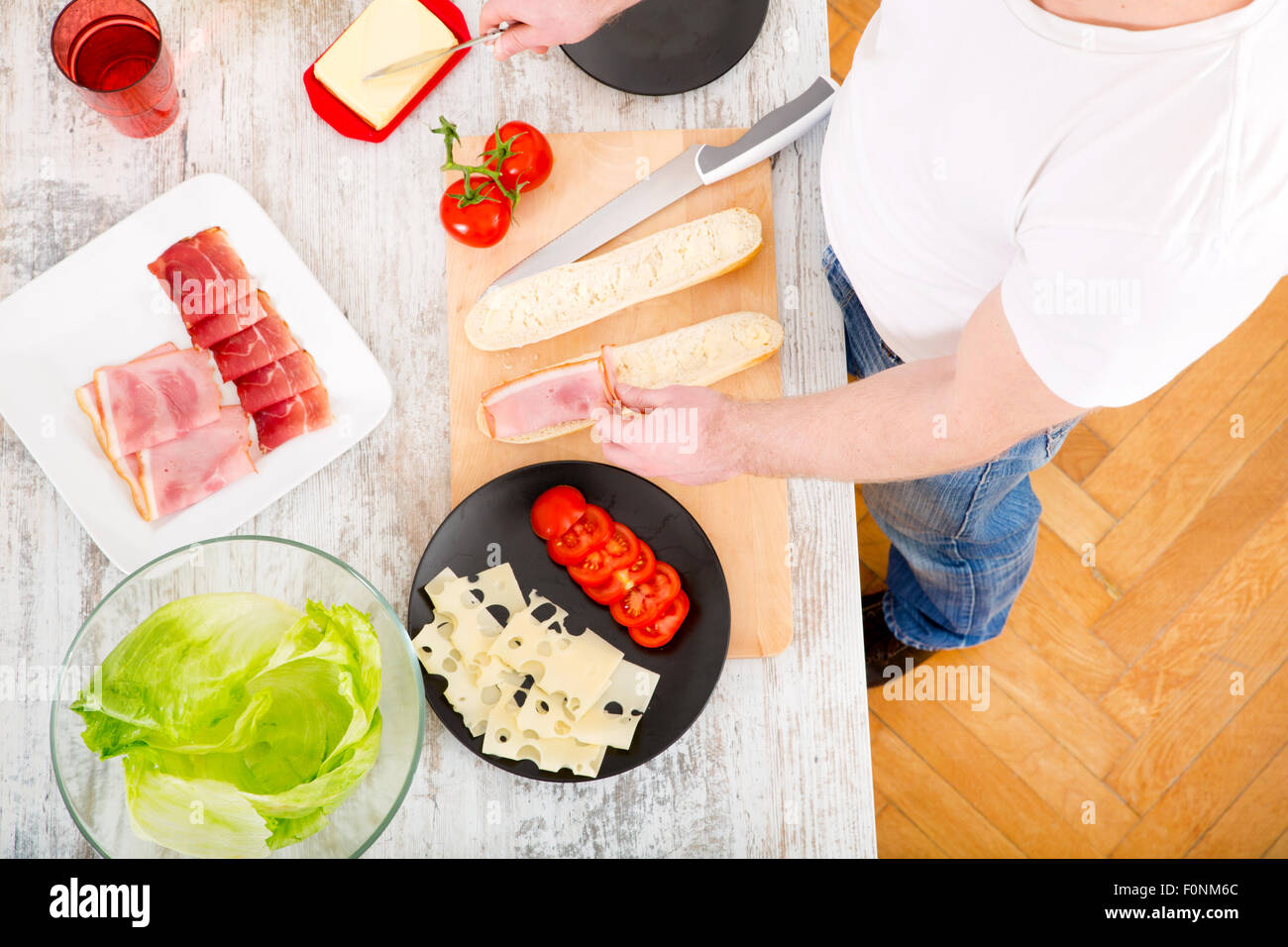 A young man preparing a sandwich in the kitchen Stock Photo - Alamy