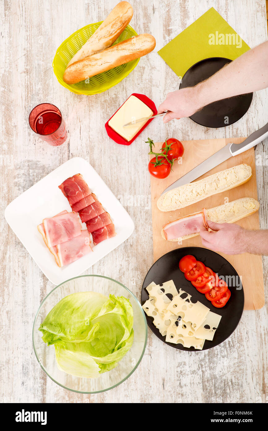 A young man preparing a sandwich in the kitchen Stock Photo - Alamy