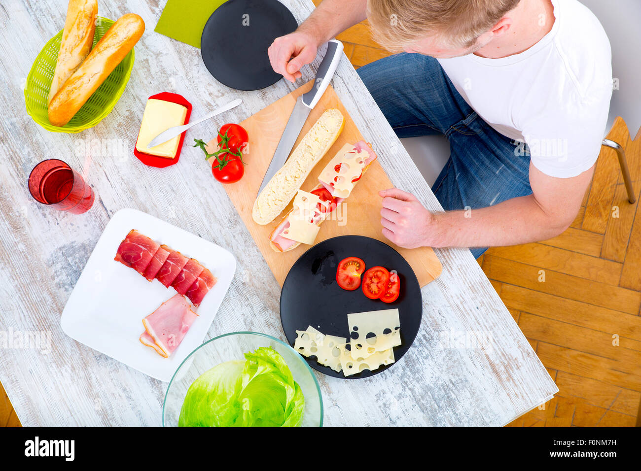 A young man preparing a sandwich in the kitchen Stock Photo - Alamy