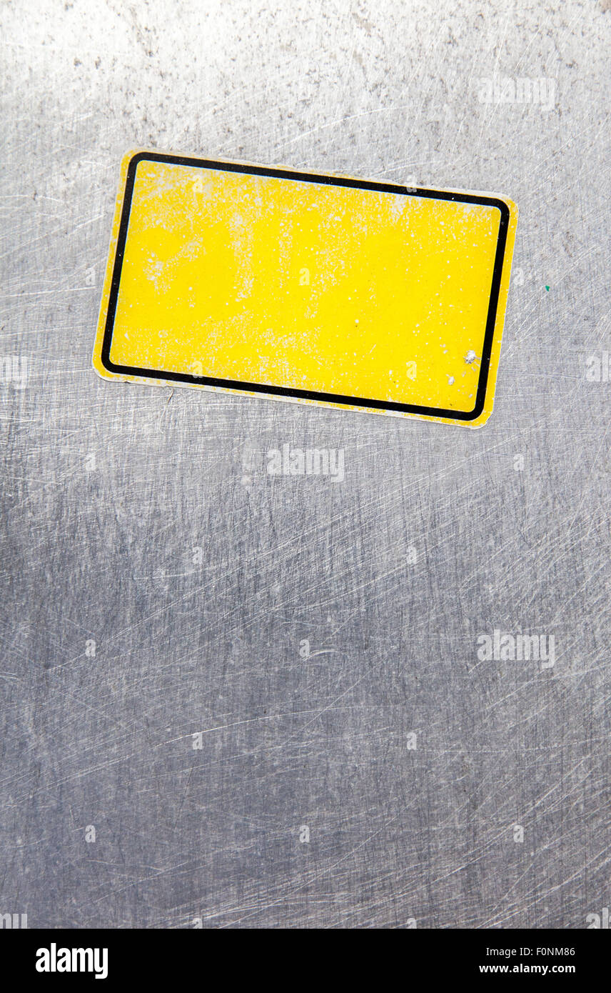 Yellow badge on stainless steel background Stock Photo - Alamy